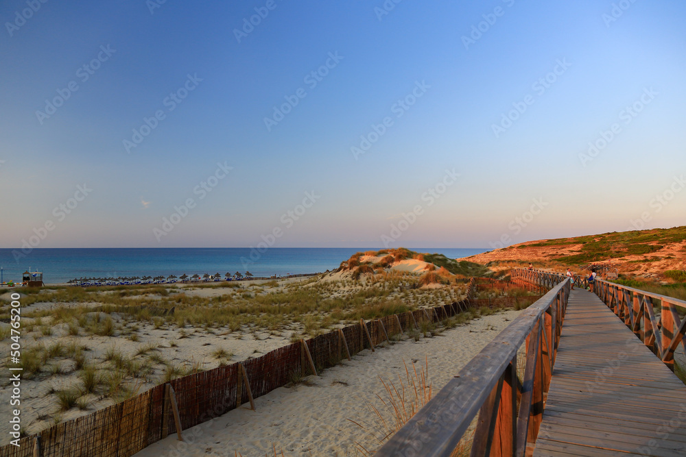 A boardwalk and fences protecting the beautiful dunes landscape of Cala ...