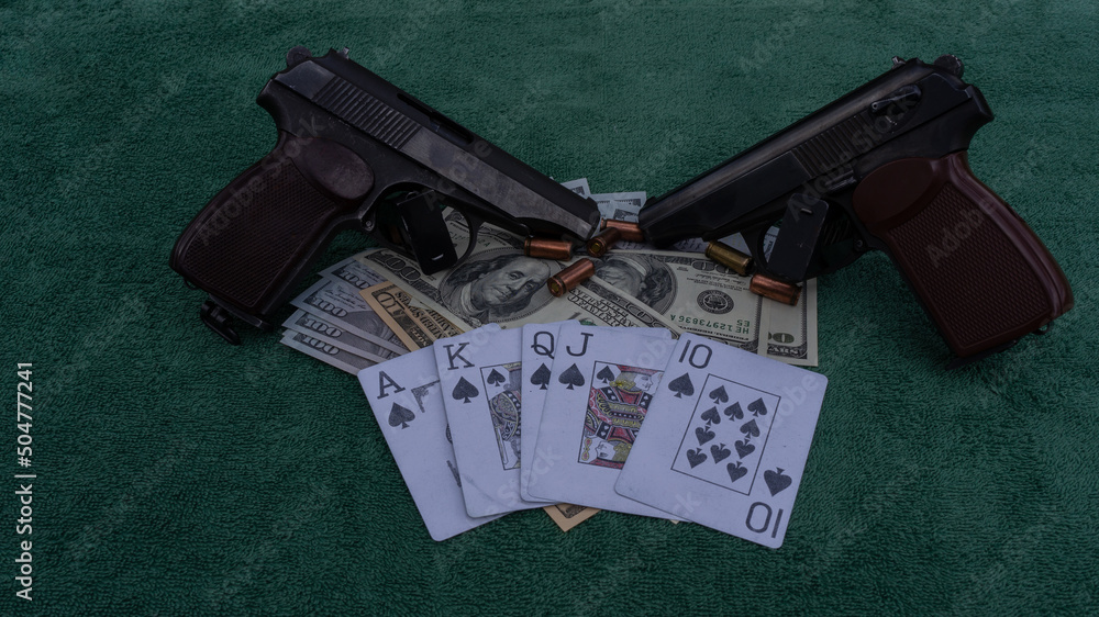 Playing poker or blackjack for money. On the green table are a pistol ...