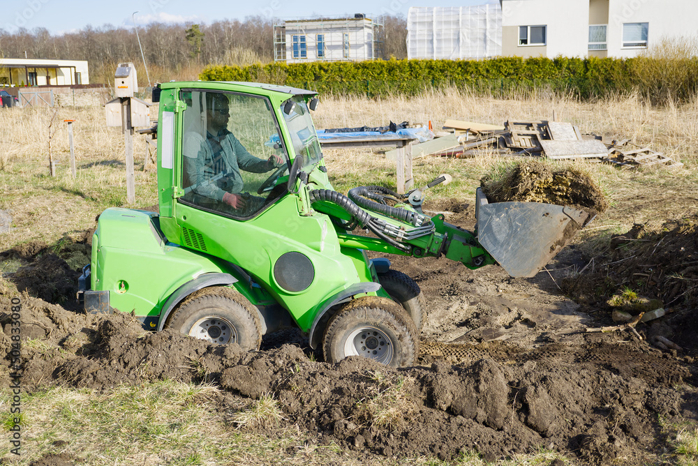 Foto de Traktor on the field. Mini traktor landscaping at home backyard ...