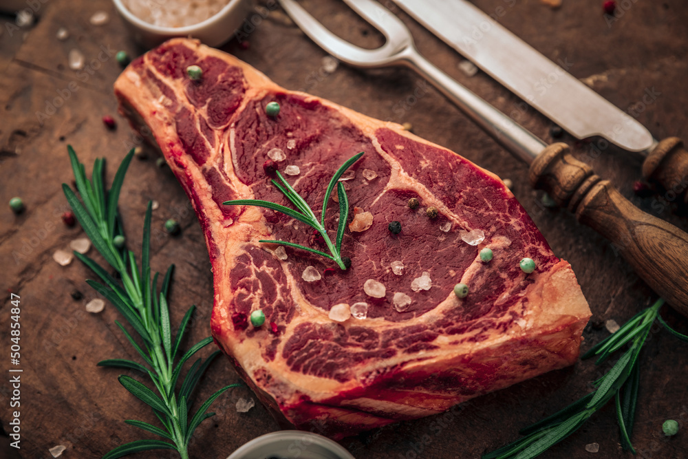 fresh uncooked beef steak with sprinkles of salt and pepper and green ...