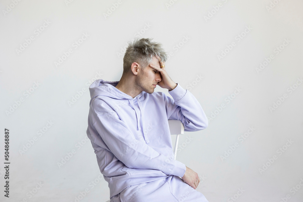 Stressed man sitting on chair against white background Stock Photo ...