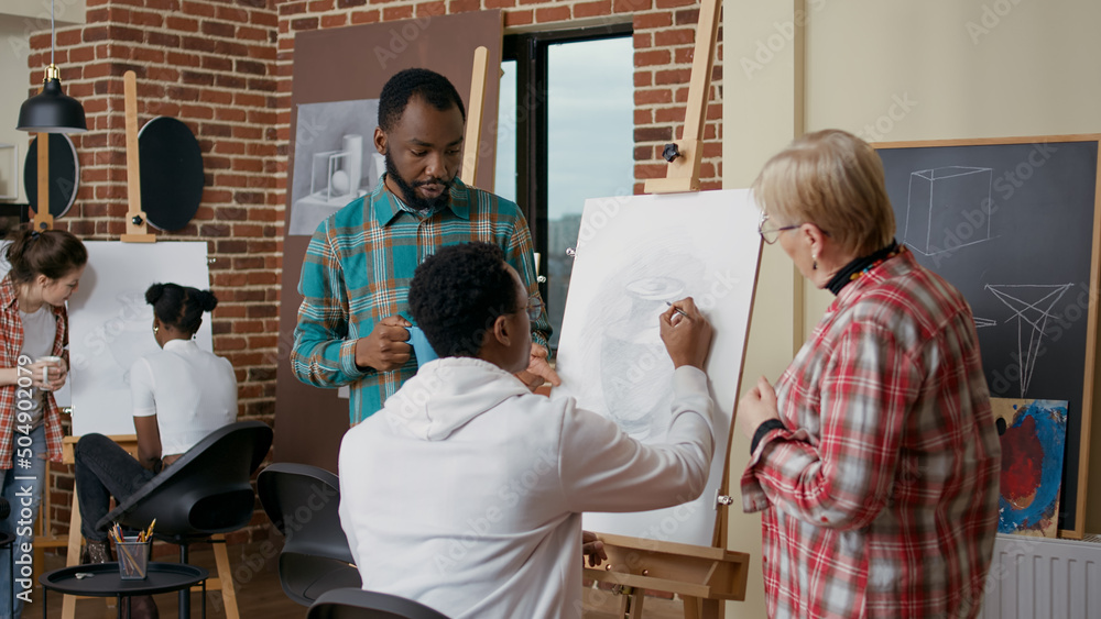 Old teacher and student helping african american man to draw vase on ...