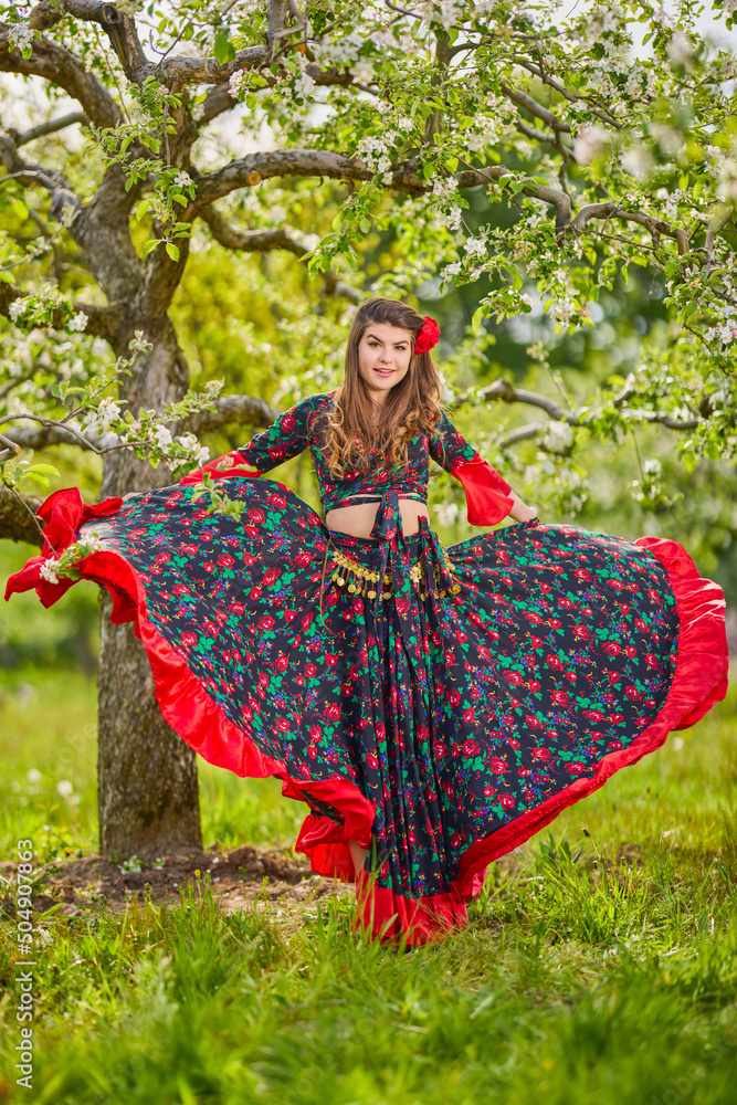 beautiful woman in traditional gypsy dress posing in nature in spring ...