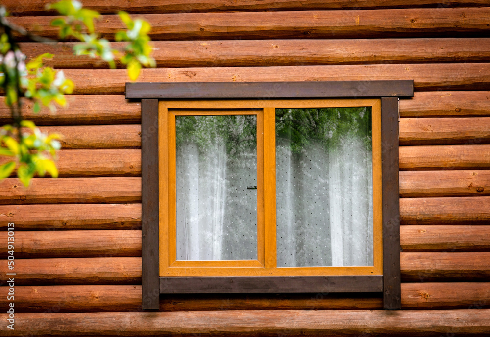 Wooden window on facade of house made of wooden beams. Pros and cons of ...