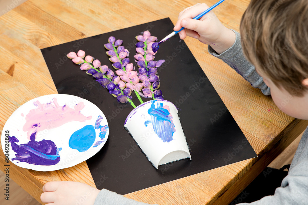 Boy painting with a gouache spring flower. Boy making color paper ...