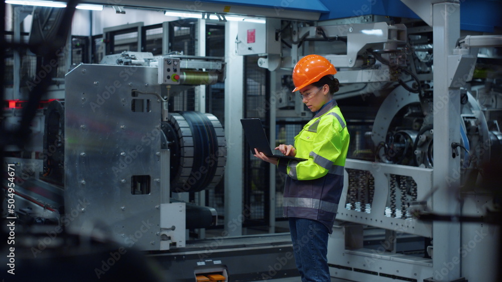 Engineer typing laptop computer wearing safety uniform on modern ...