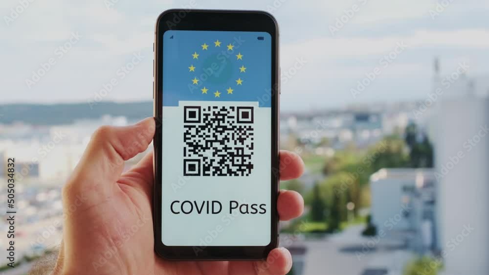 Covid Pass with QR code on screen of smartphone in male hand. Man shows ...