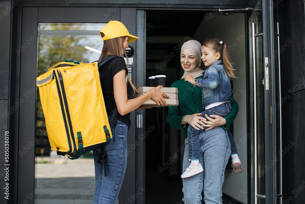 Female caucasian courier giving pizza boxes and takeaway coffee from ...