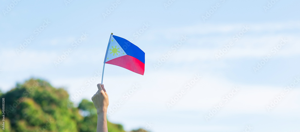 hand holding Philippines flag on nature background. 12th June of ...