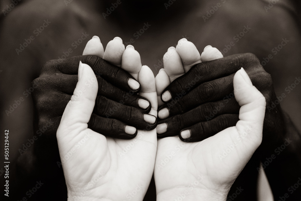 Black person holding hands of white person in sign of compassion and ...