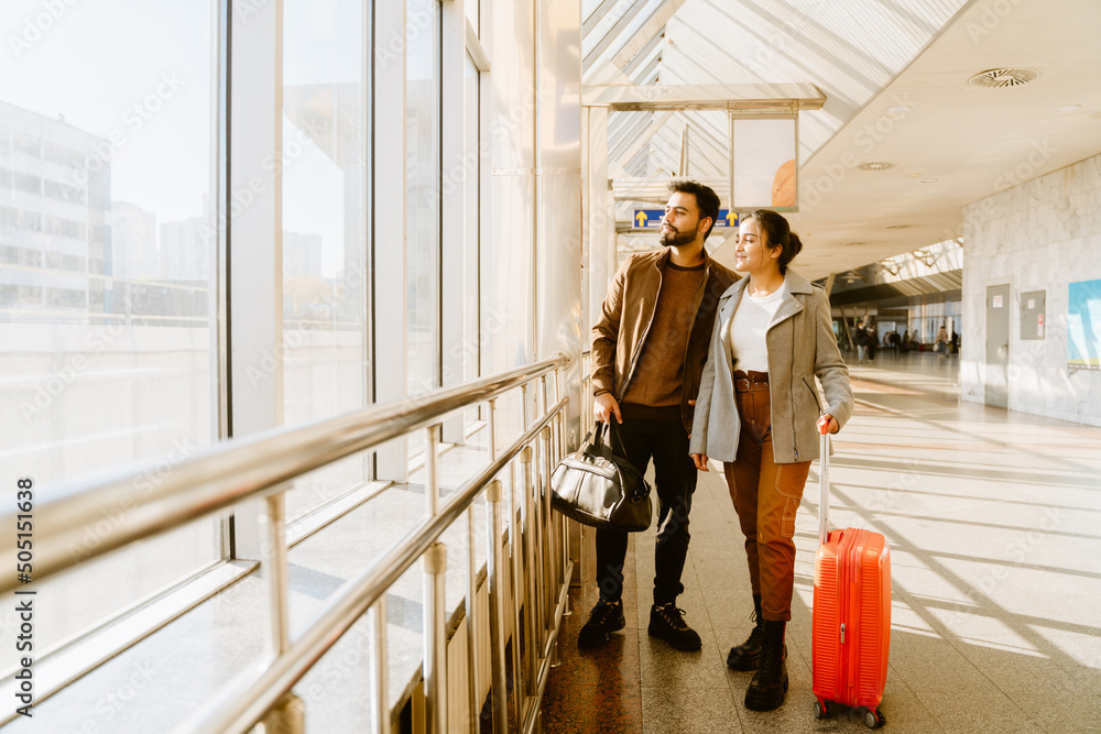 Young indian couple looking in window together at airport Stock Photo ...