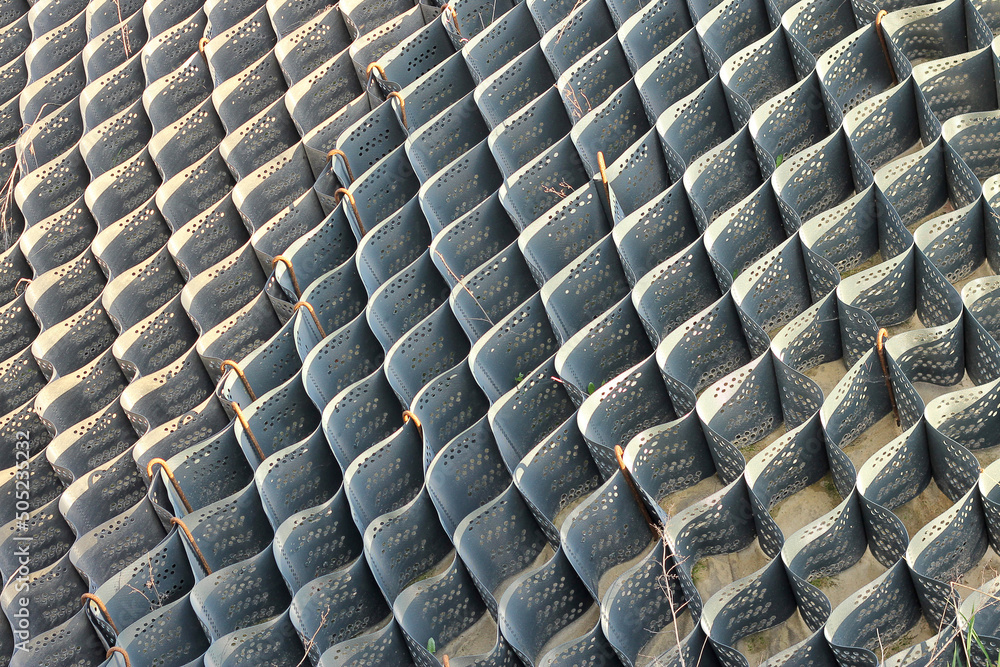 Polymer geogrid is not filled with soil. Strengthening the slope with a ...