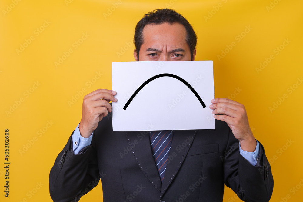 Dissappointed man in business suit is frowning and covering half his ...