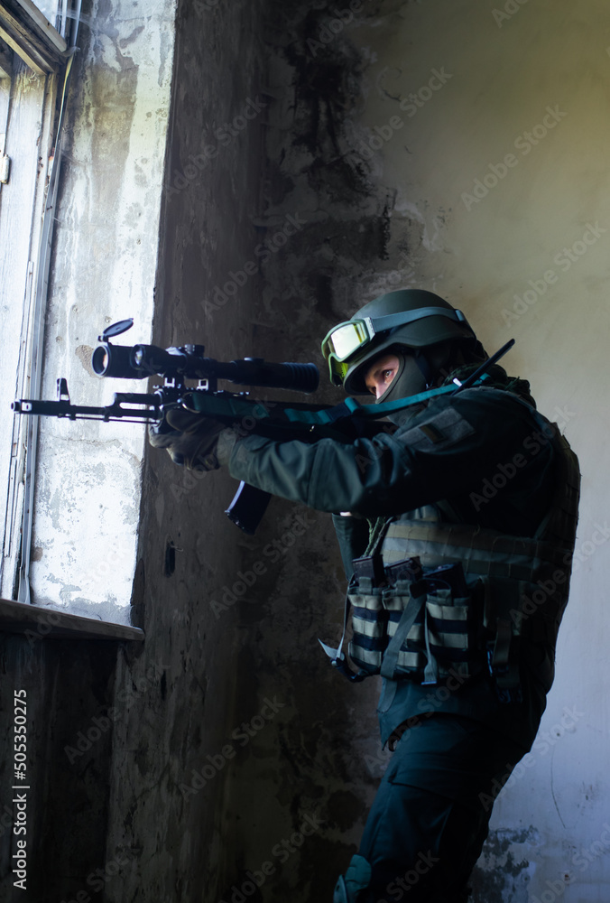 Ukrainian military sniper militant in helmet ammunition aims a rifle at ...