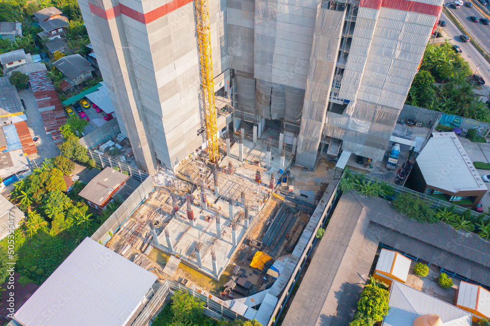 Aerial view of busy industrial under construction site workers working ...