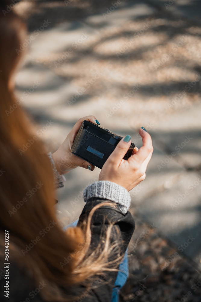 Girl reloading her old film camera after she took a picture. She is in ...