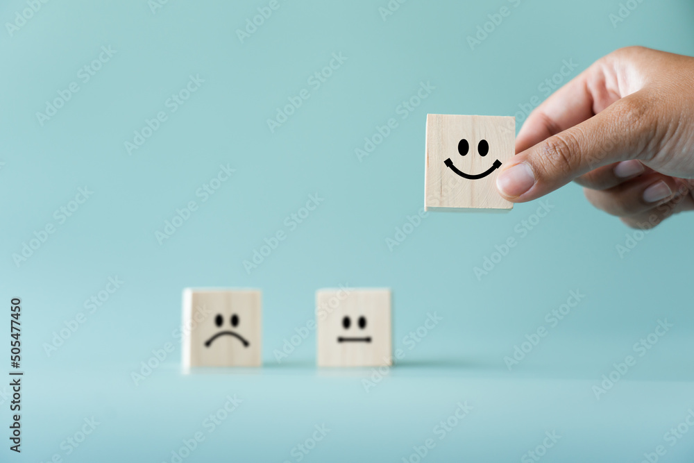 Concept of customer satisfaction review. Wooden blocks with facial ...