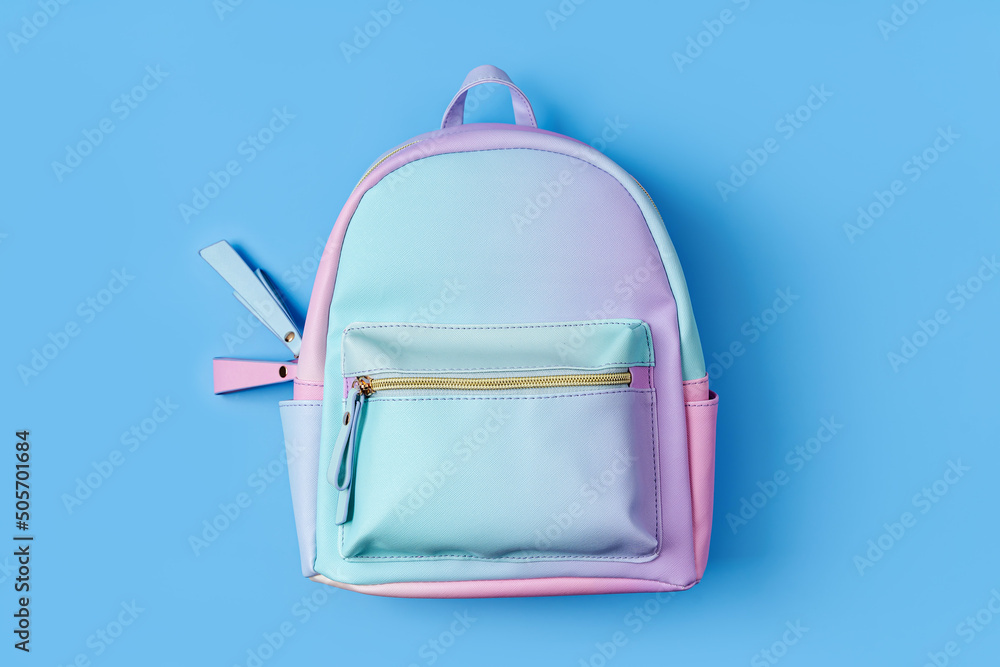 School backpack in pastel color on blue background. Concept back to ...