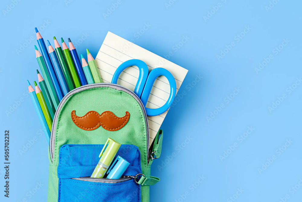 Opened Pencil case with stationery on blue background. Concept back to ...
