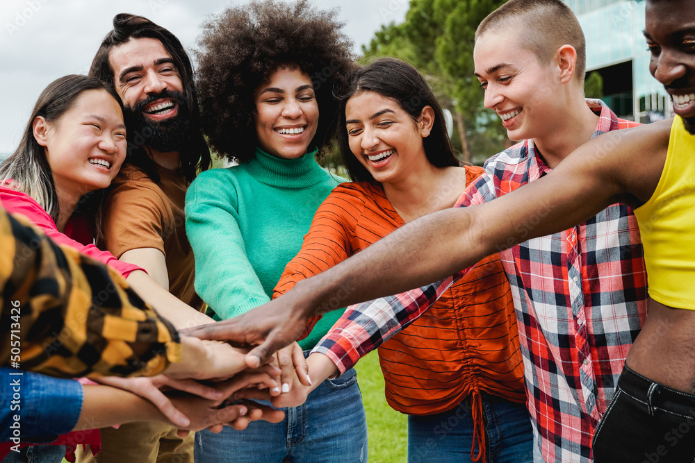 Young multiethnic group of people stacking hands together outdoor ...