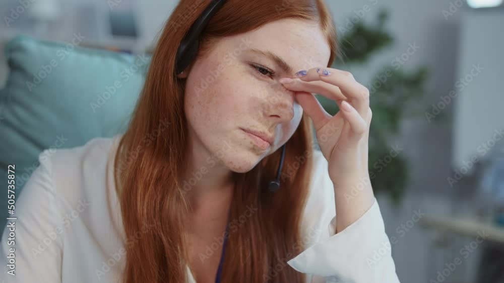 Stressed call center woman in front of computer screen with headset ...