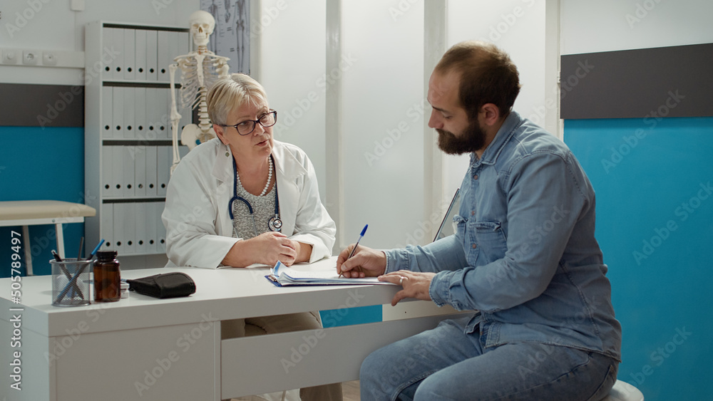 Sick patient signing checkup documents to receive medication and ...