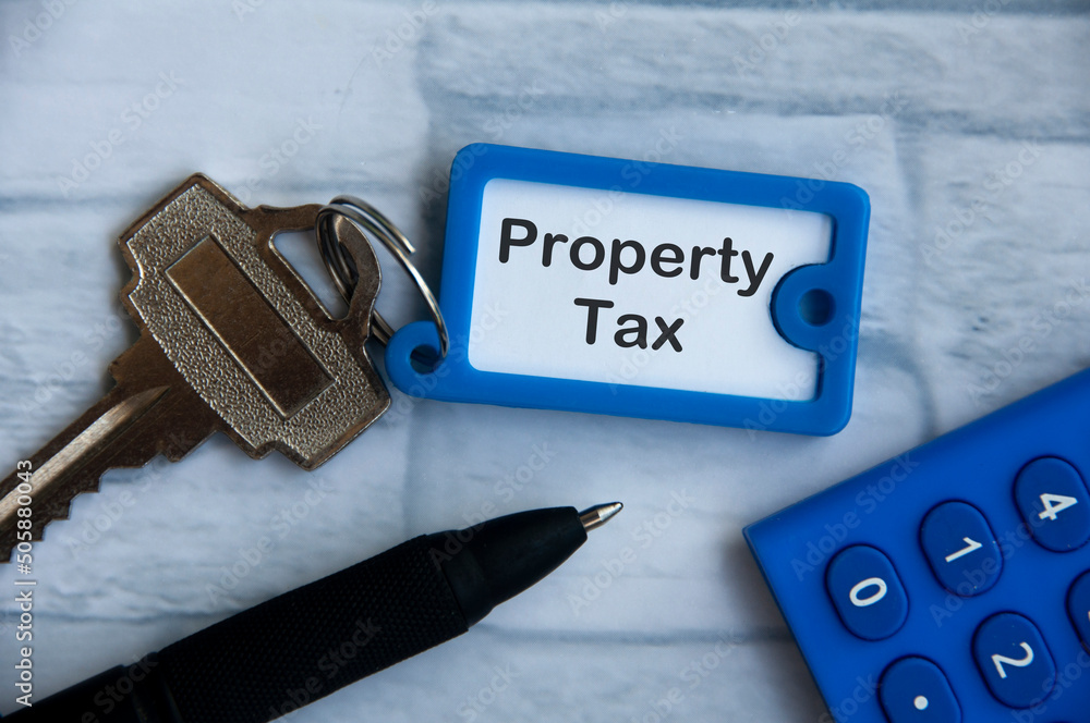 Property tax labeled on keychain with pen and calculator background ...