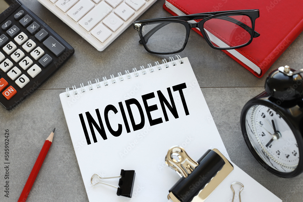 INCIDENT words on notepad on gray background near keyboard and ...