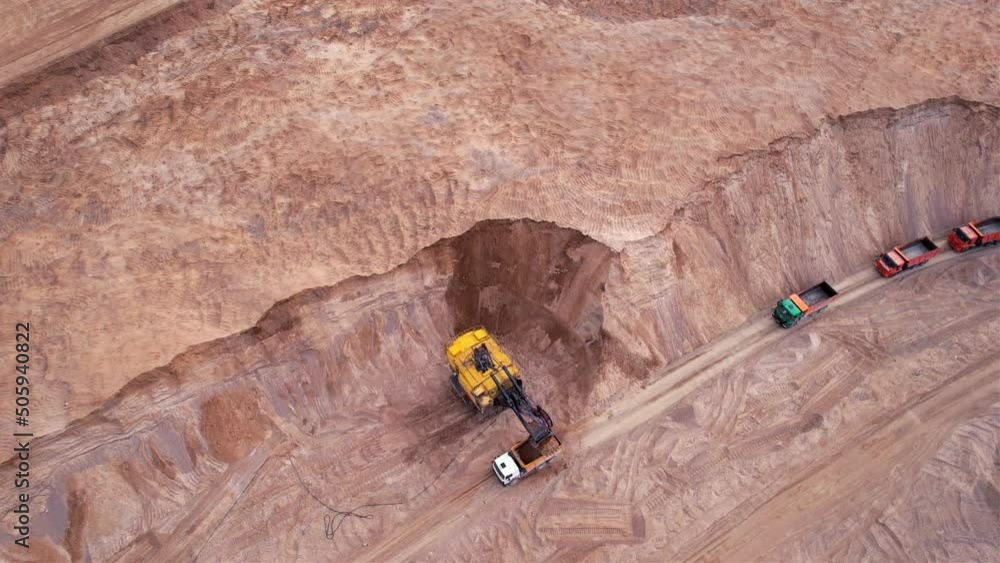Mining excavator loads sand into dump truck. Excavator loads sand rock ...