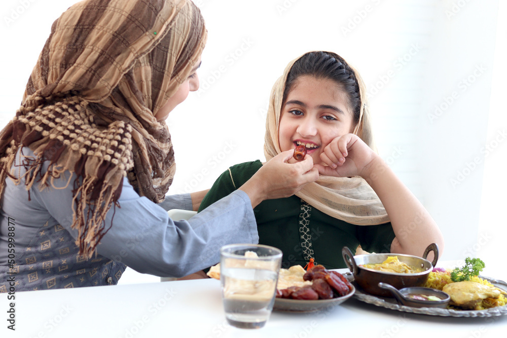 Adorable Pakistani Muslim girl sits at kitchen table, kid with hijab ...