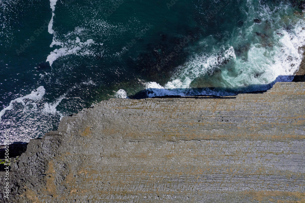 Ocean waves hit cliffs. Rough stone coastline of Aran island, county ...