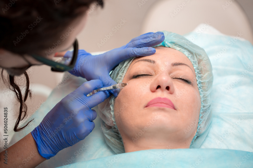 Injection facial rejuvenation. The cosmetologist injects cosmetic ...