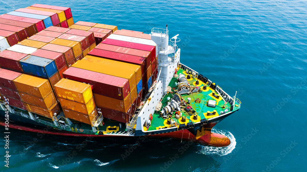 Aerial side view of cargo ship carrying container and running for ...