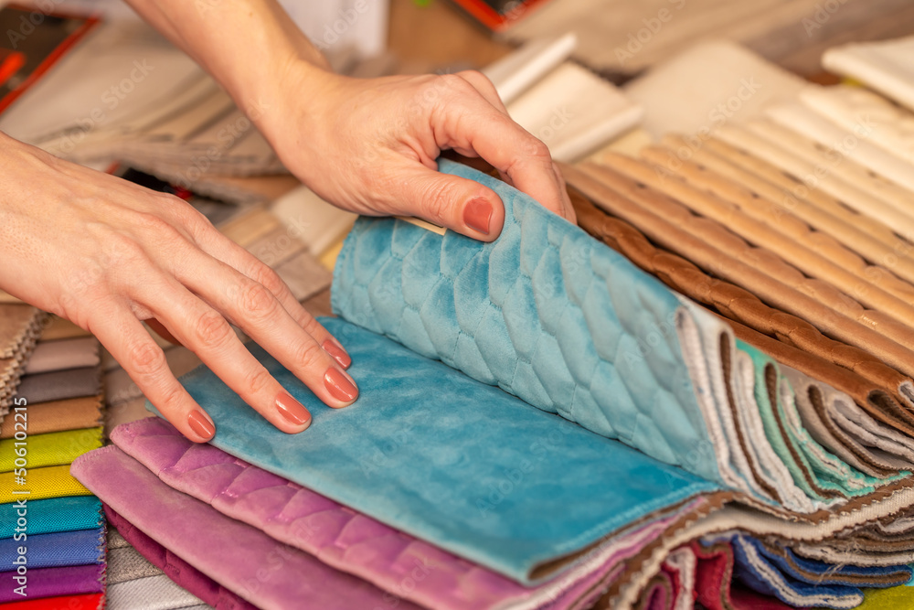 Fabric swatches in different colors are stacked for selection. A woman ...