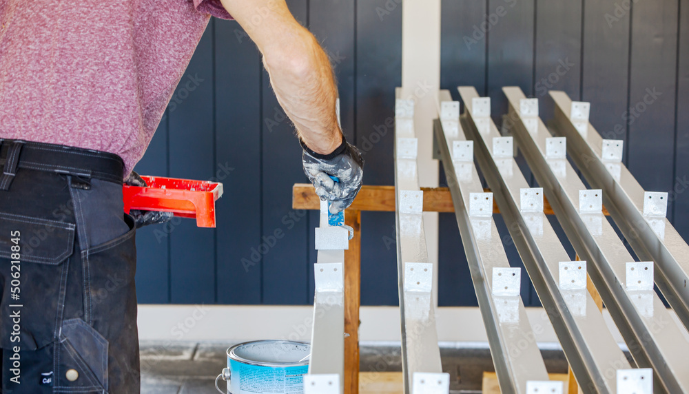 Painting metal Steel beam outside with paint roller. hand of Handyman ...