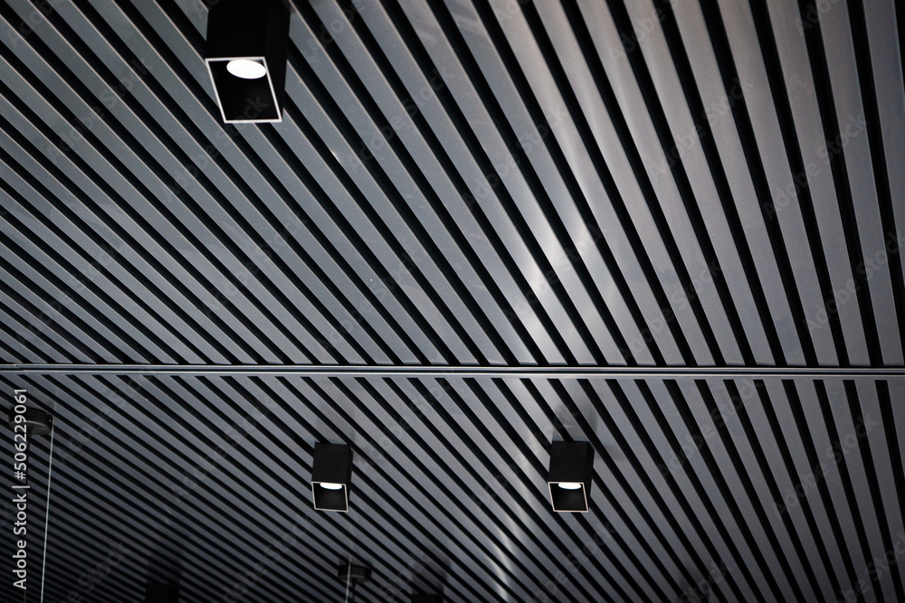 Bottom view of lath ceiling with spot lights. Abstract modern ...