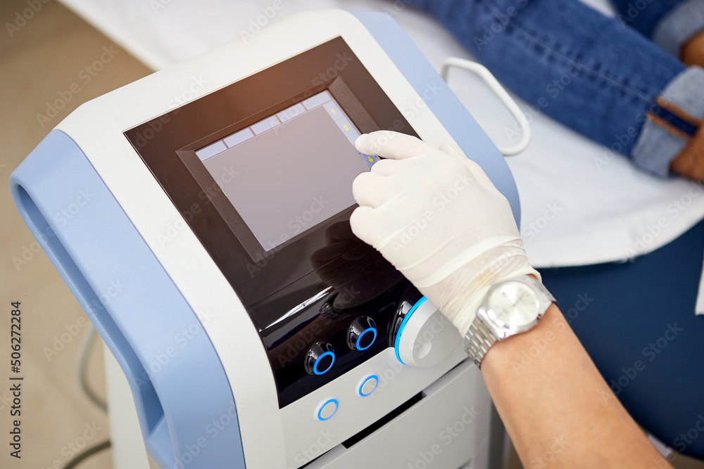 Shock wave therapy of the heel spur. Physiotherapist doctor uses ...