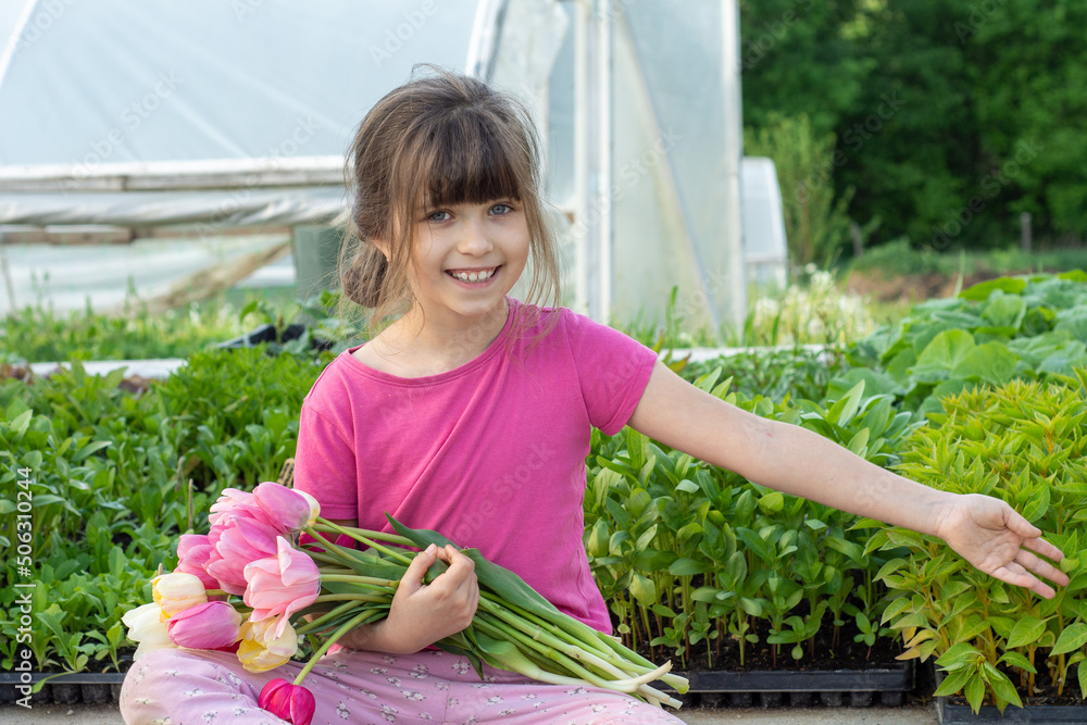 Girl with a bouquet of flowers tulips at an organic flower farm ...