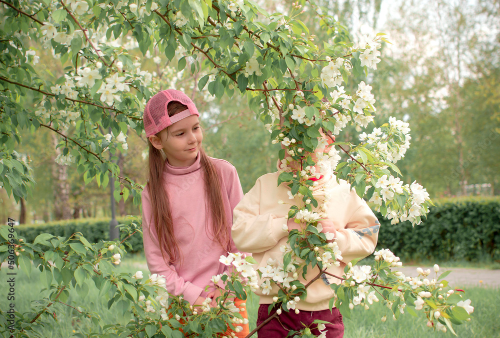 Happy children in the park with apple trees. Against the background of ...