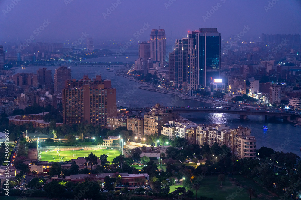 Egypt, Cairo, River Nile,Illuminated city park at dusk with river Nile ...