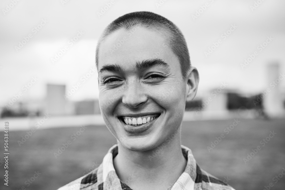 Bald girl smiling on camera at city park - Focus on face - Black and ...