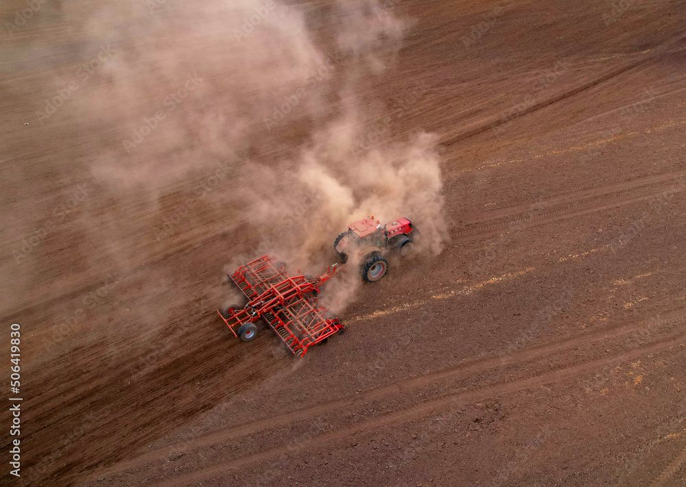 Tactor with disk harrow on plowing field. Cultivated land and soil ...