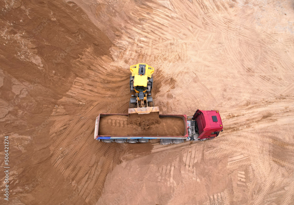 Wheel loader load sand in tipper truck in open pit. Front end loader on ...