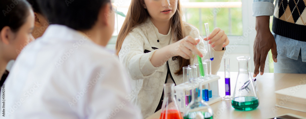 Young teacher teaching group student about science and test chemical ...