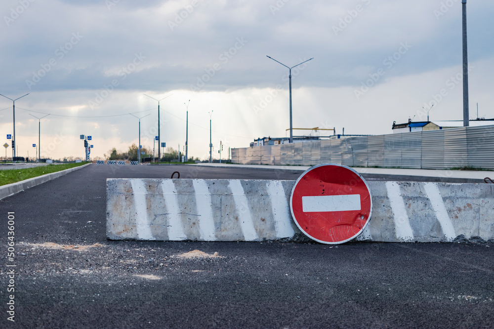 A stop road sign and concrete blocks block the entrance to the ...