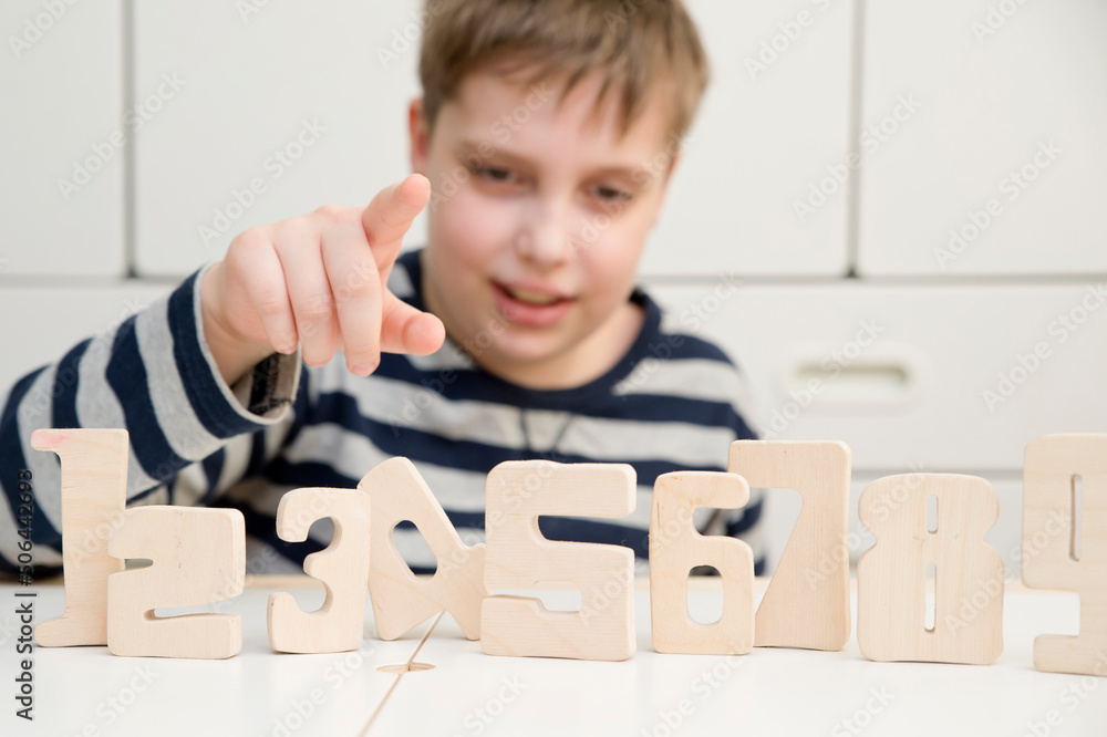 Puzzle numbers. The boy plays with wooden numbers. Early education ...