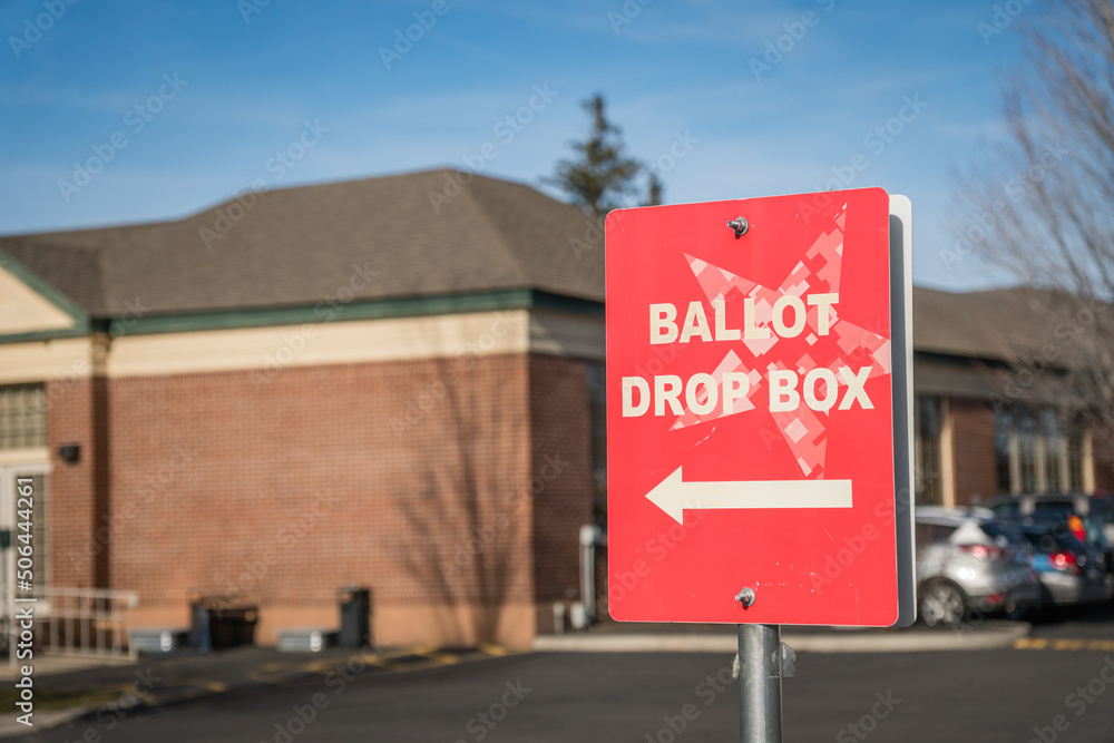 Bright red sign reading Ballot Drop Box at voting location. Selective ...