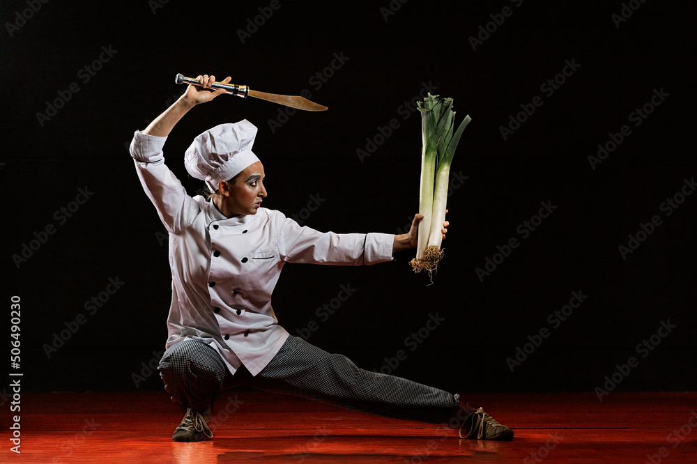 Young female mime artist with knife and leeks performing martial arts ...