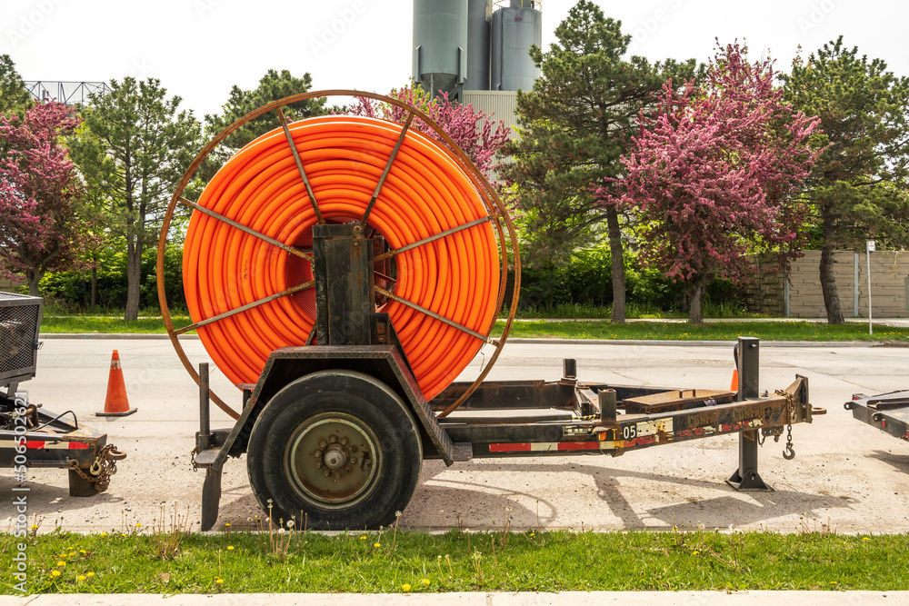 Large spools of smooth walled HDPE plastic cable (orange) conduit on ...