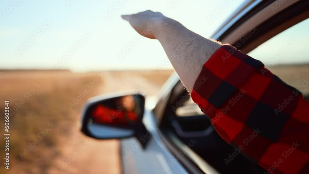 Man of a car while driving. Tourist puts her hand out of window to feel ...